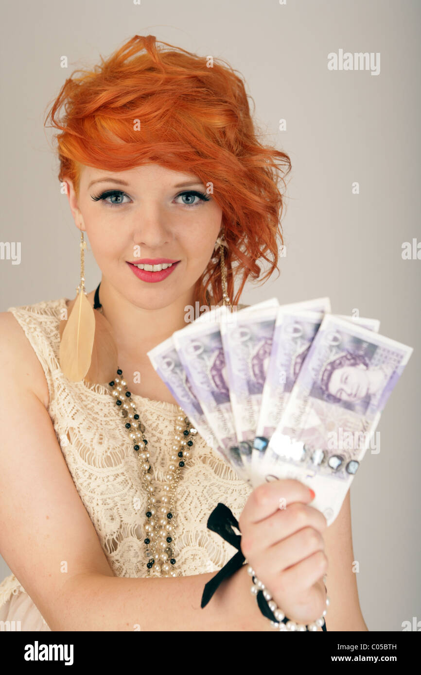 teenage girl holding a fan of £20 notes in her hand Stock Photo - Alamy