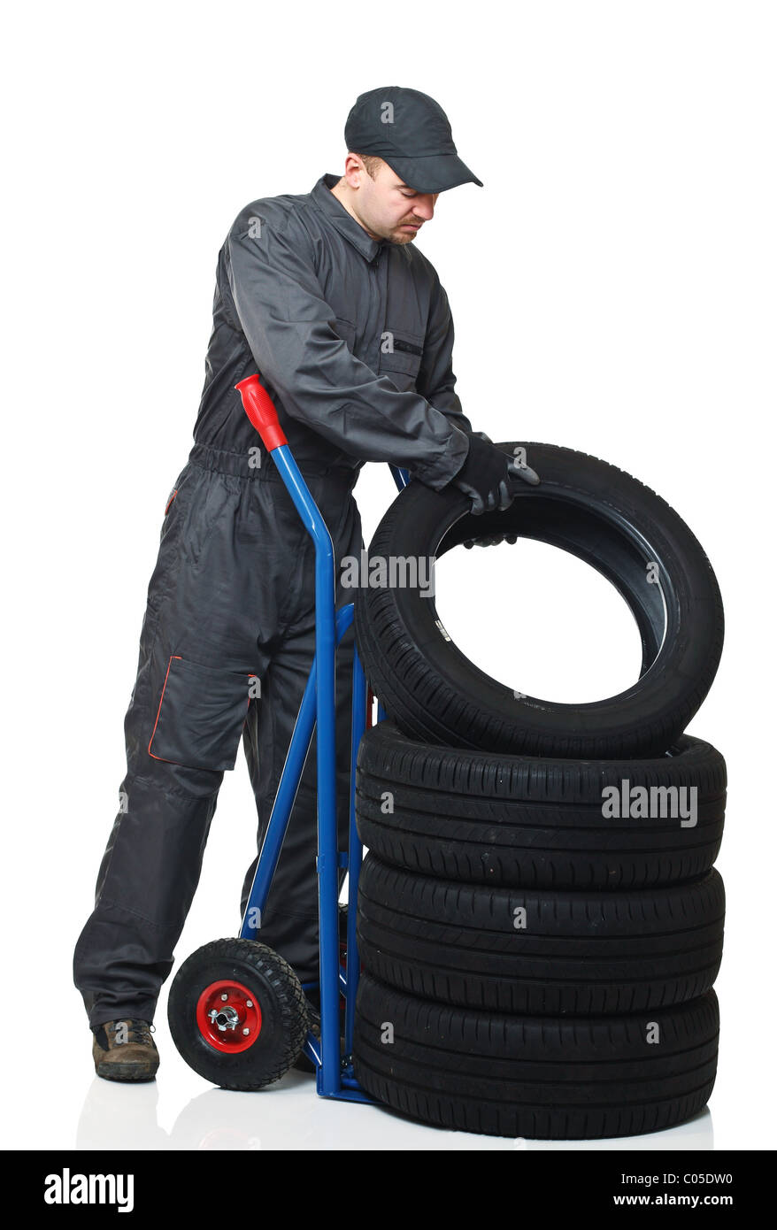 caucasian mechanic pose tire on handtruc isolated on white background ...