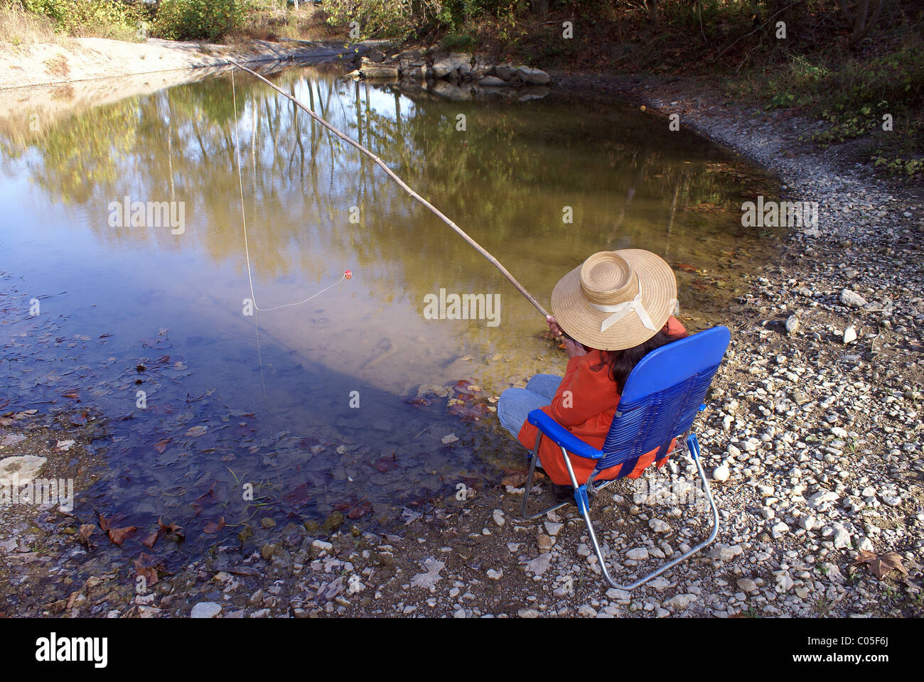 Looking down on woman fishing in pond Stock Photo - Alamy