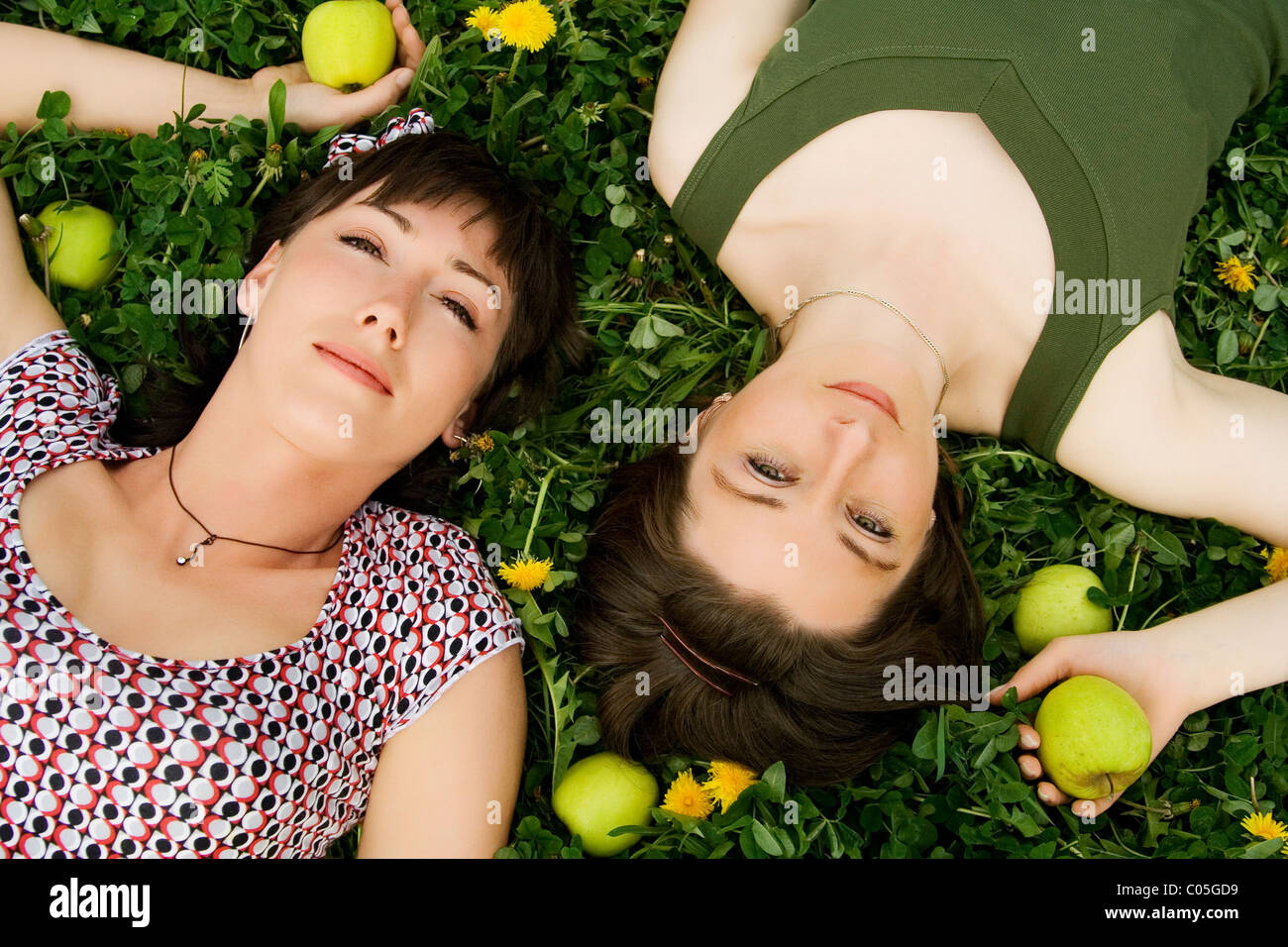 two young woman recumbent in grass Stock Photo - Alamy