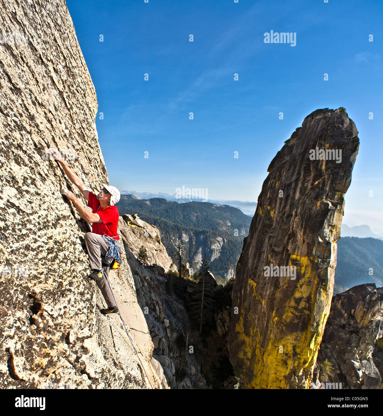 Climber struggles for his next grip on a steep rock wall Stock Photo ...