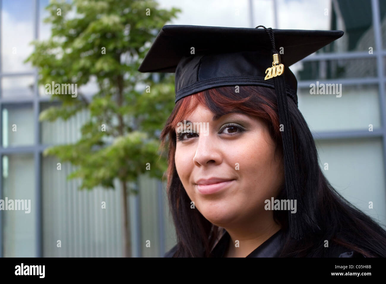 A recent graduate posing in her cap and gown Stock Photo - Alamy