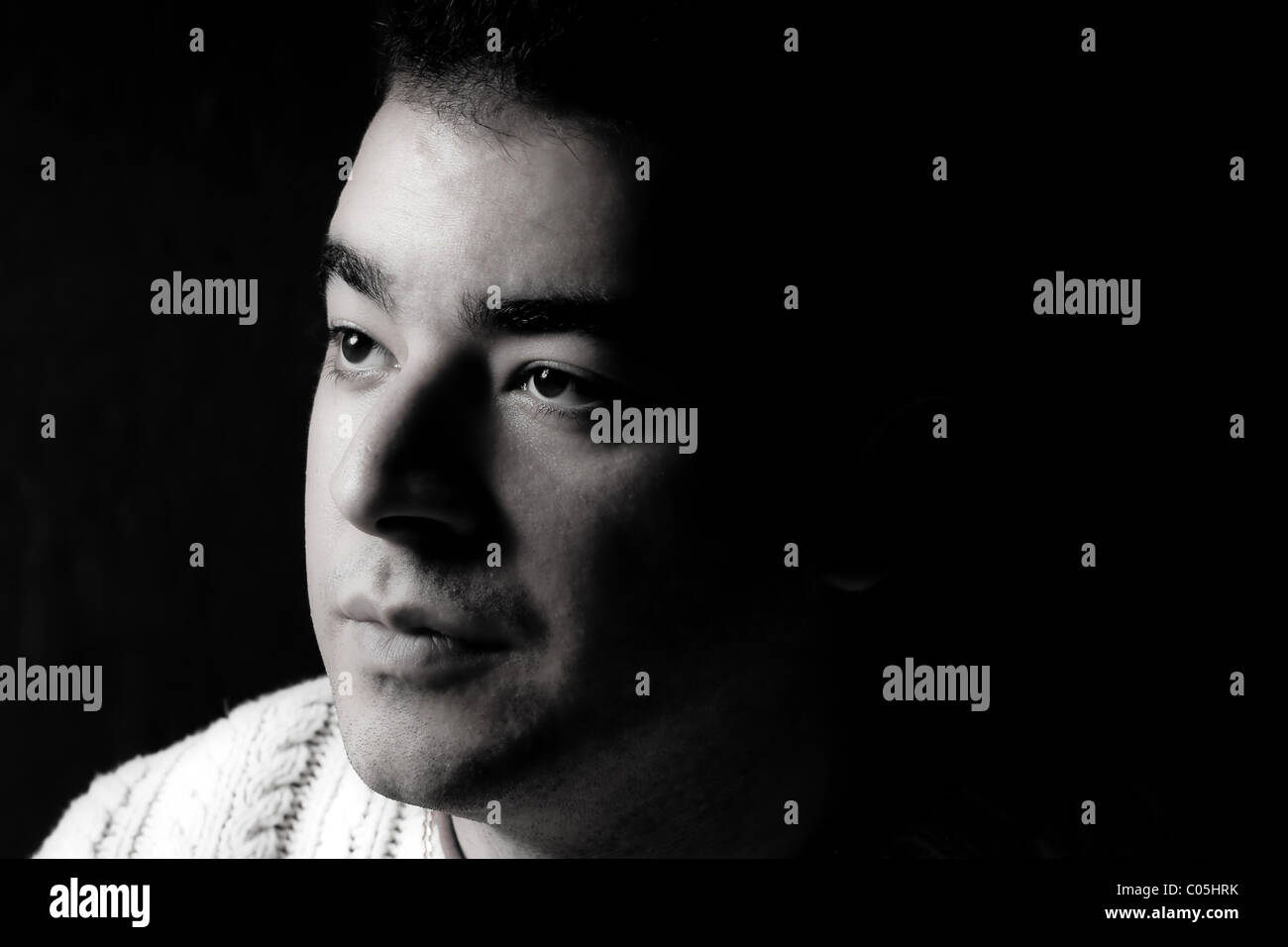 Portrait of a serious young man in dramatic lighting Stock Photo - Alamy