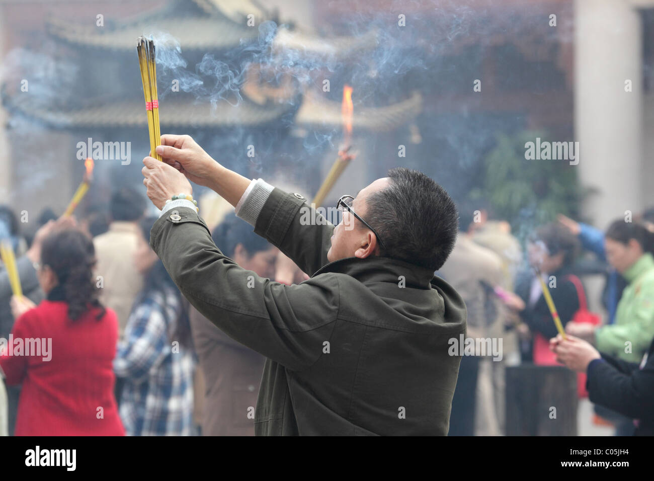 Praying Person with Incense Sticks at Buddhist temple in Shanghai ...