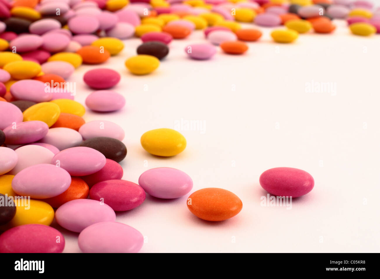 Colorful candy coated chocolates in a frame composition with space for ...