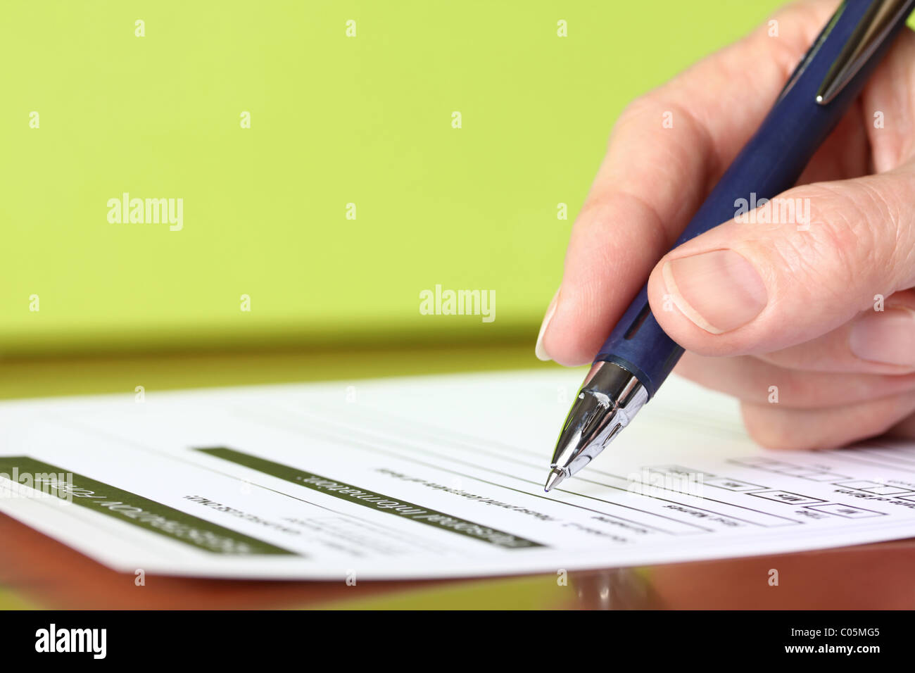 Hand with Pen Signing Form Closeup on Green Background Stock Photo - Alamy