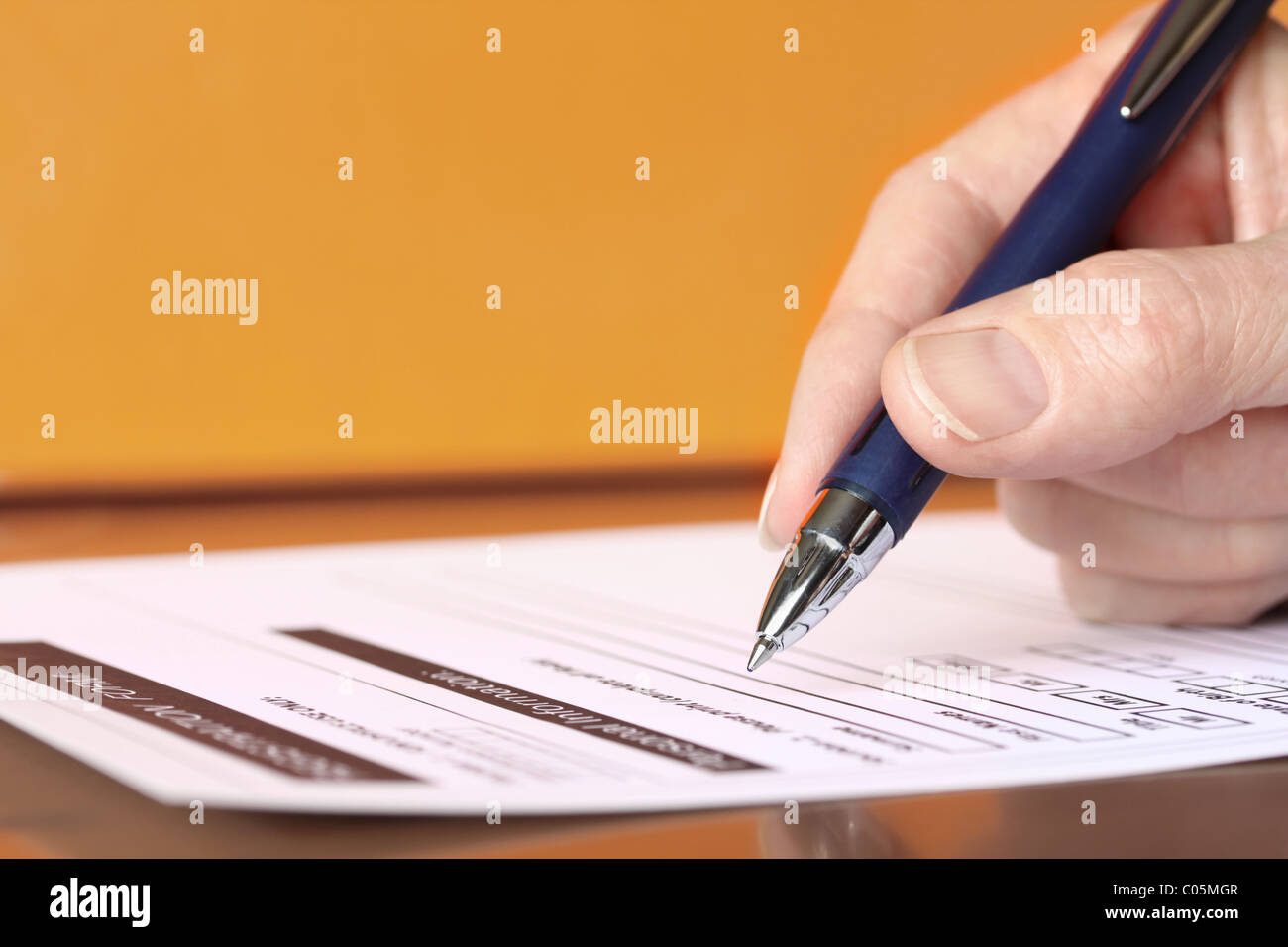 Hand with Pen Signing Form Closeup on Orange Background Stock Photo - Alamy