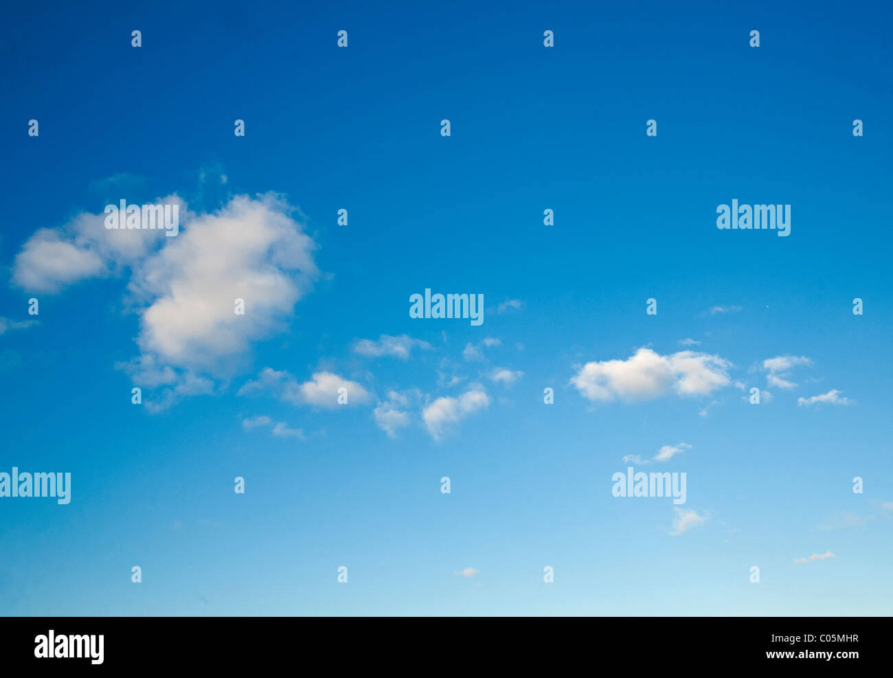 Small cumulus clouds in a clear blue sky Stock Photo - Alamy