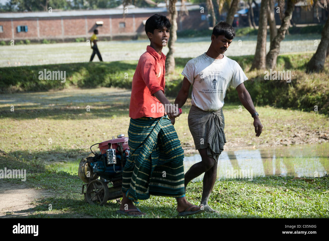 Bangladeshi men pulling a water pump, designed to pump water in and out ...