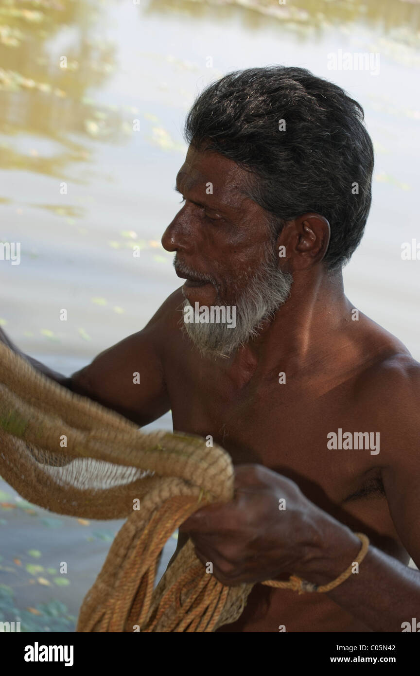 A Bangladeshi fisherman, fishing in the traditional way, preparing to ...