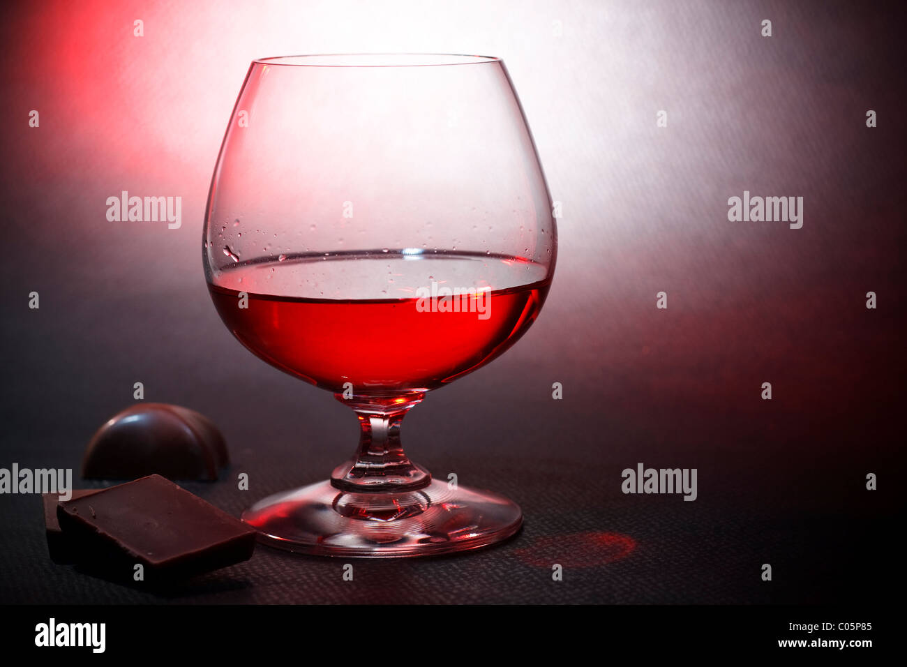 Luxury red liqueur on crystal balloon glass and milk chocolate ...