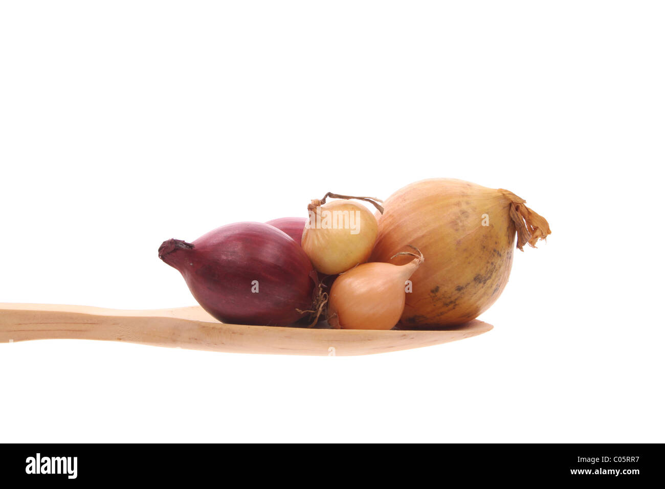 Onions simply offered on a wooden spoon isolated on a white background ...