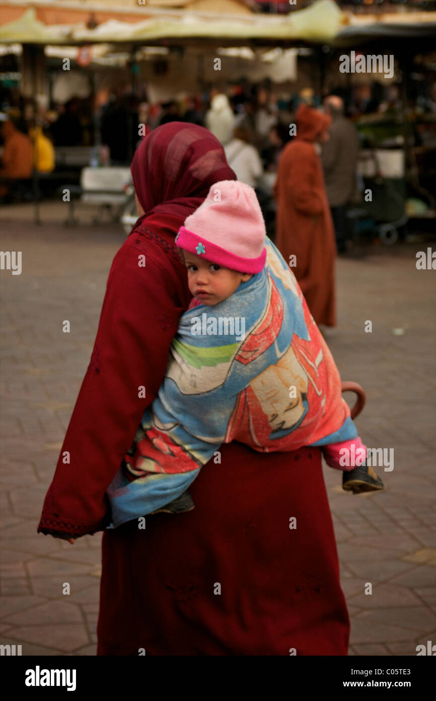 Moroccan woman carrying baby on her back in Marrakech Stock Photo - Alamy