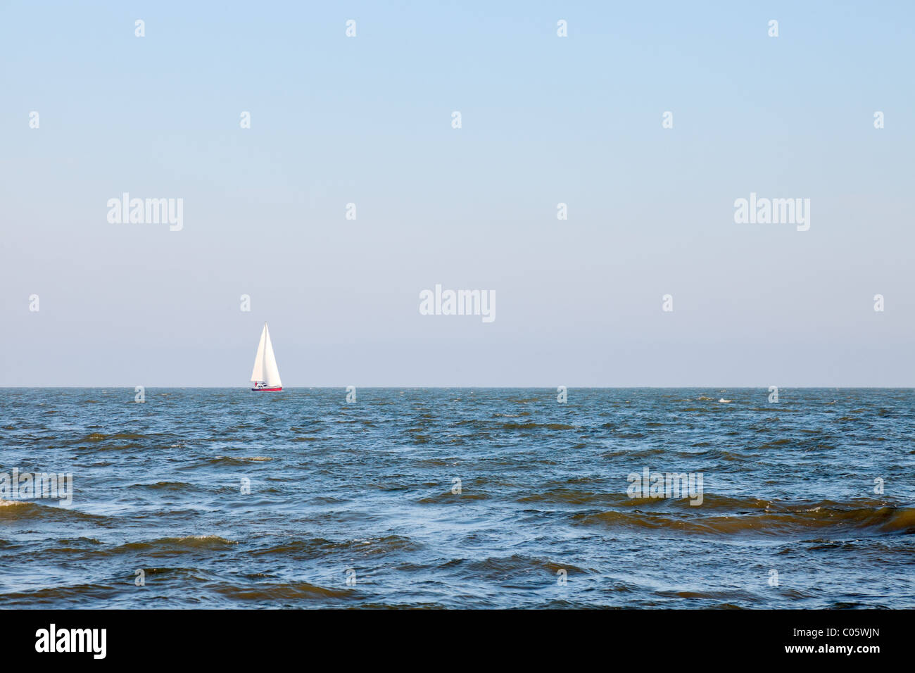 Empty sea with sailing boat on clear day Stock Photo - Alamy