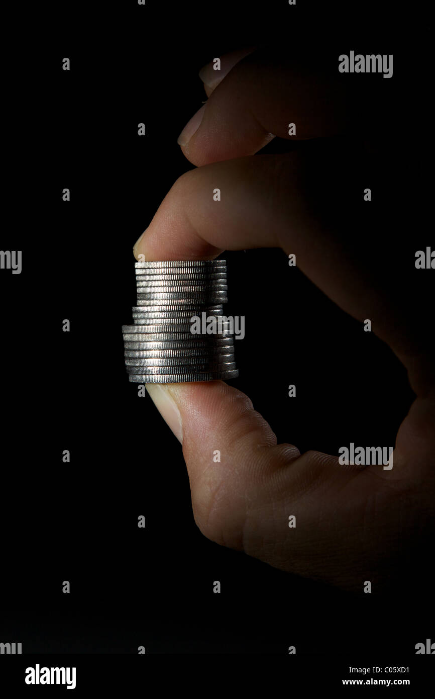 Coin money between fingers hi-res stock photography and images - Alamy