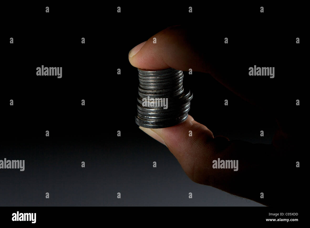 A hand and holds money in coins between the finger tips with clear ...
