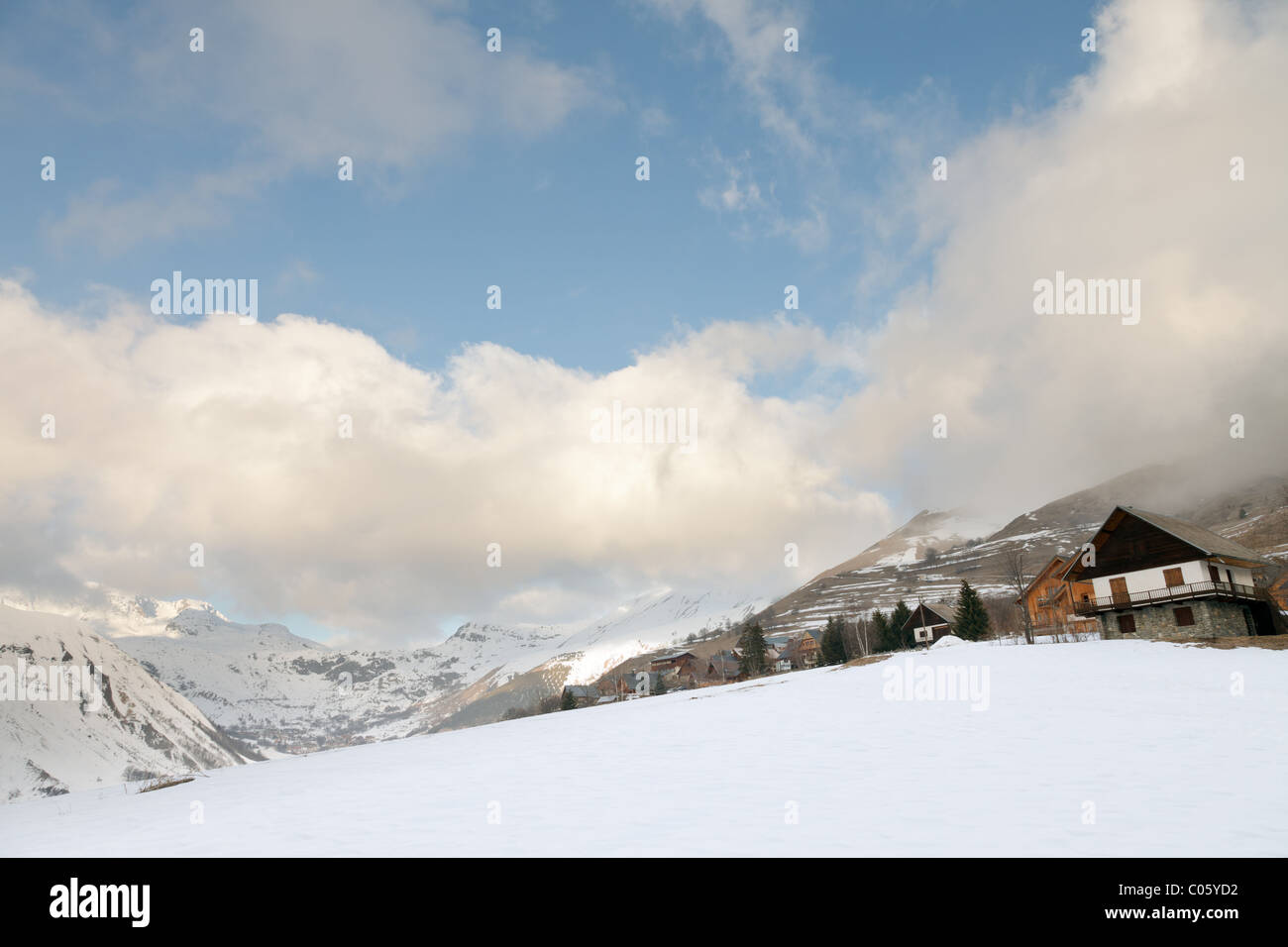 Alpine winter scenery with chalets under blue cloudy sky. Landscape ...