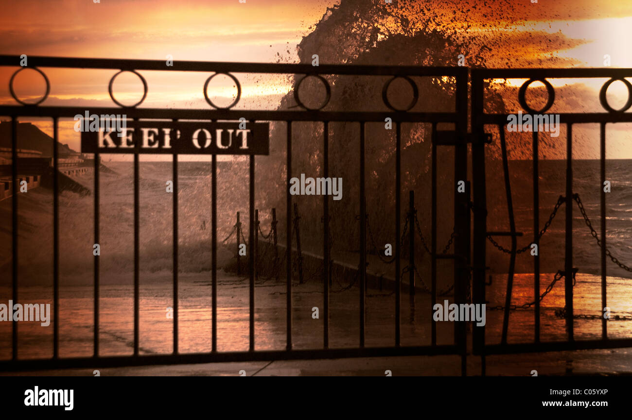 Keep Out sign on a metal gate with railings and trees in the background ...
