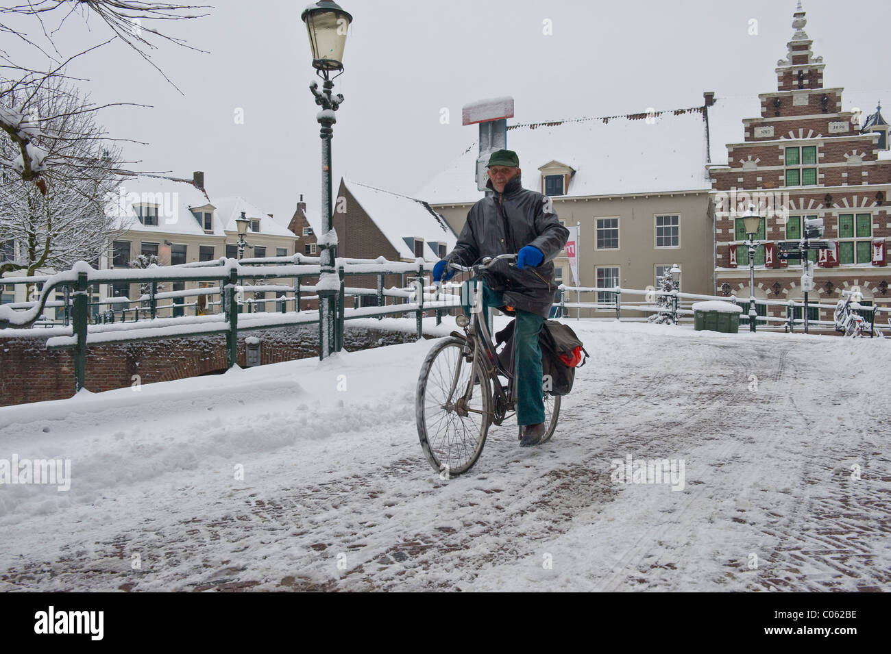 Dutchman riding his bicycle on an icy road in Amersfoort, Netherlands ...