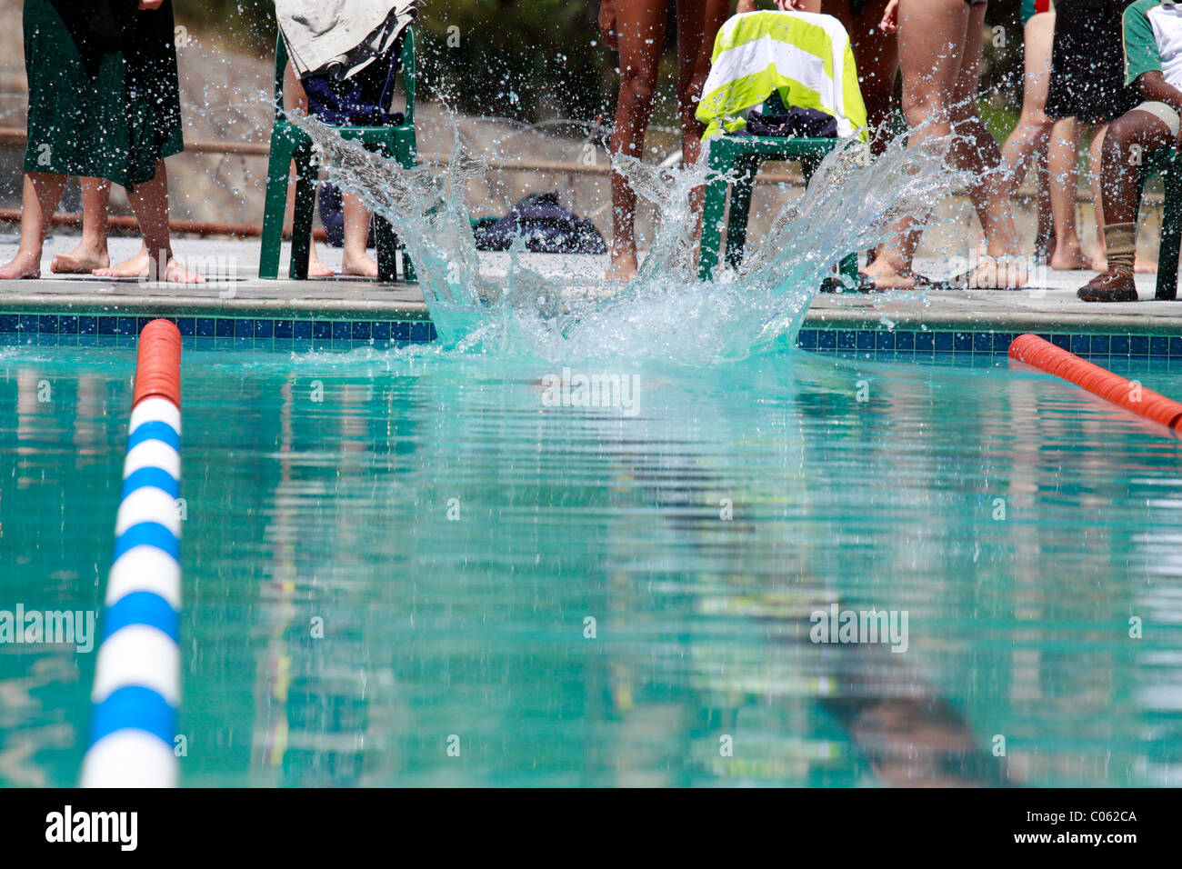 Water splashing as swimmer dives into pool during inter house gala at ...