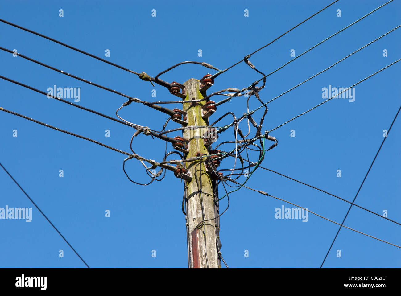 A "telegraph pole" with many overhead utility supply cables or wires on ...