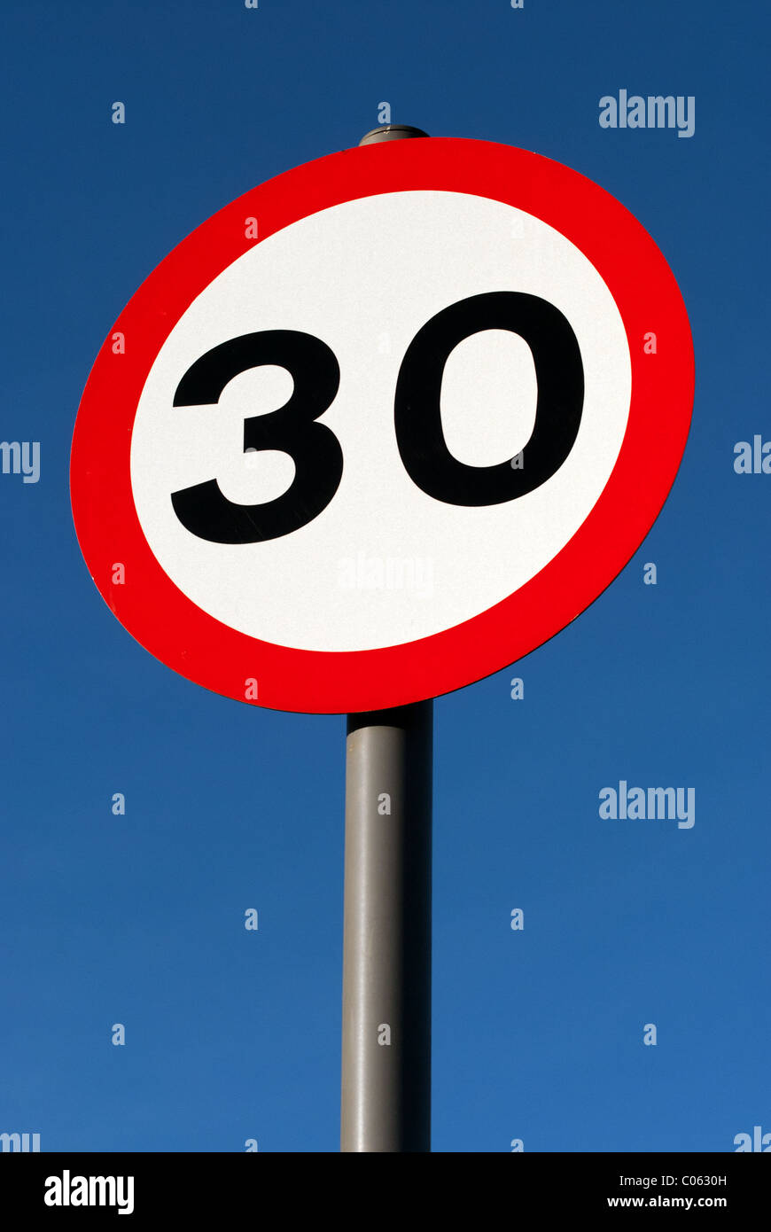 A UK 30 mph speed limit sign against a deep blue sky Stock Photo - Alamy