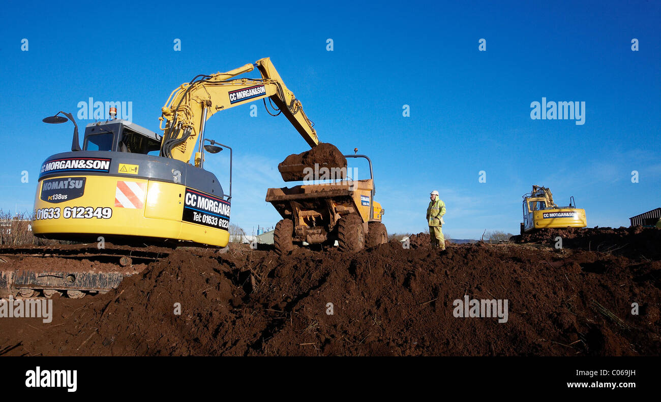 Mechanical diggers excavating earth on a building site in Wales, UK ...