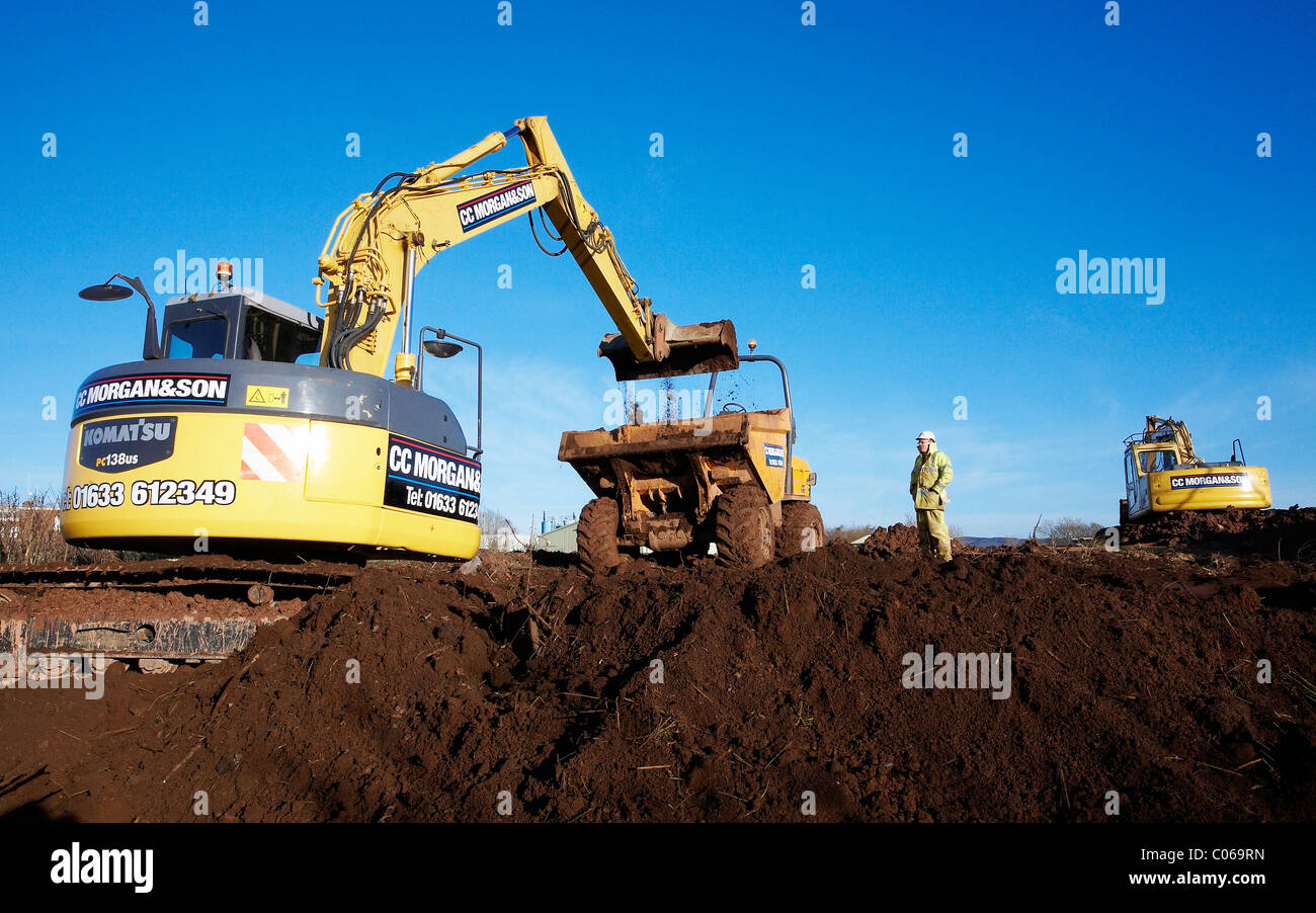 Mechanical diggers excavating earth on a building site Stock Photo - Alamy