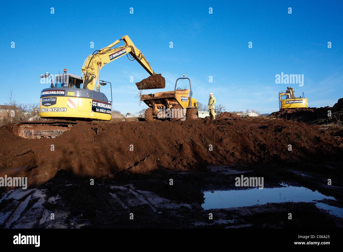 Mechanical diggers excavating earth on a building site Stock Photo - Alamy