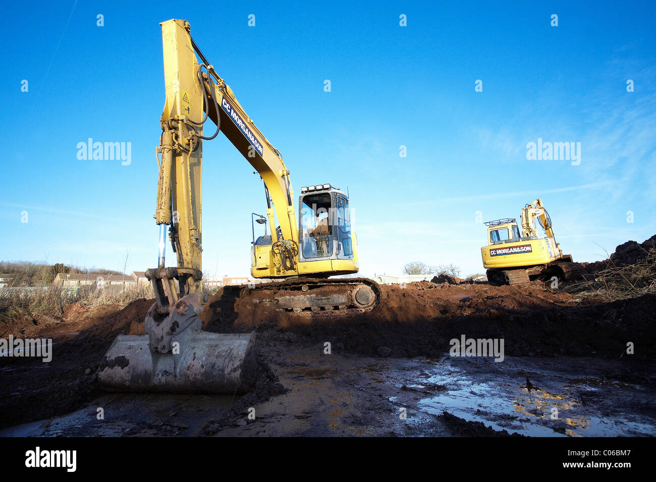 Mechanical diggers excavating earth on a building site Stock Photo - Alamy