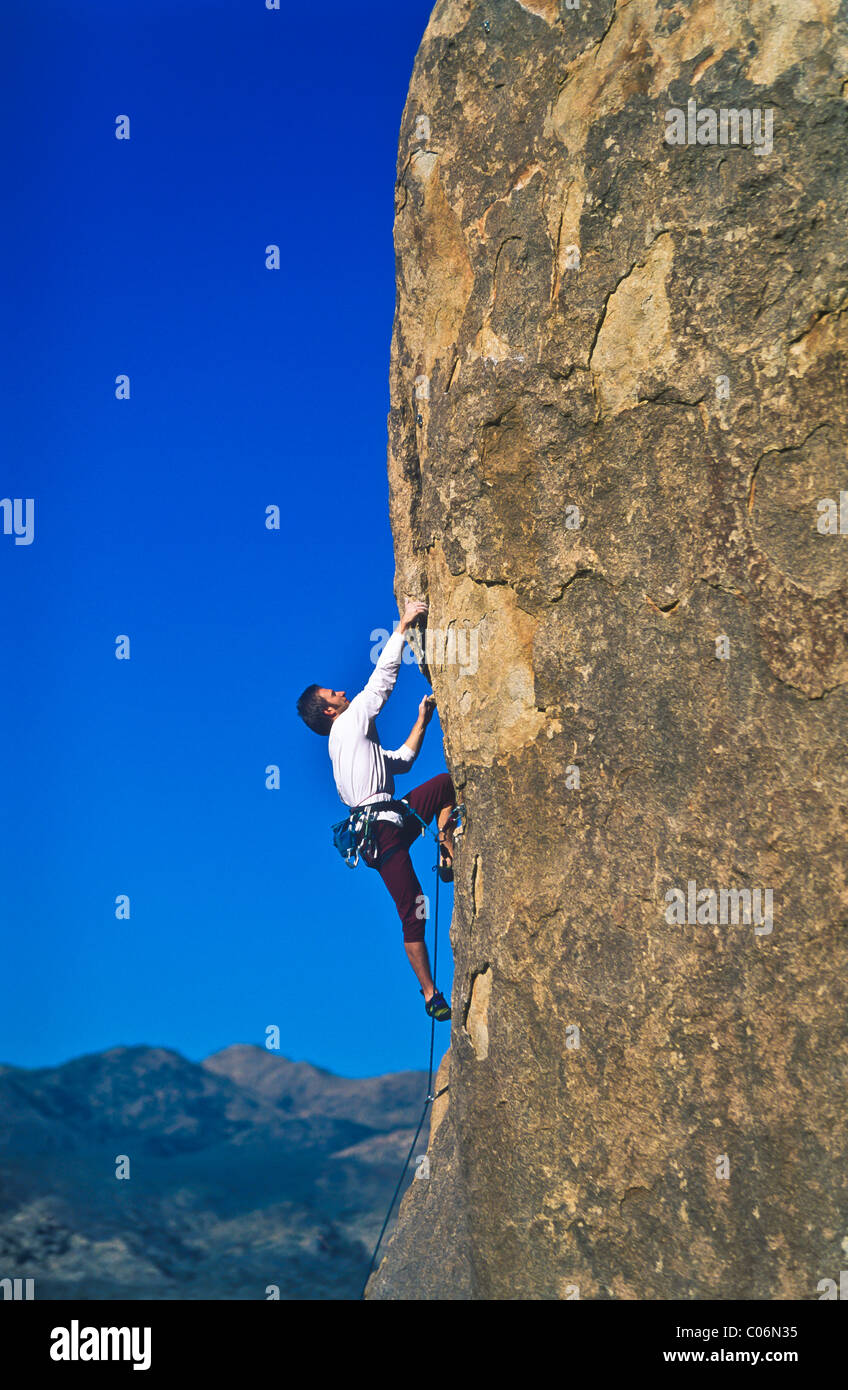 Rock climber struggles for his next grip on a overhanging cliff Stock ...