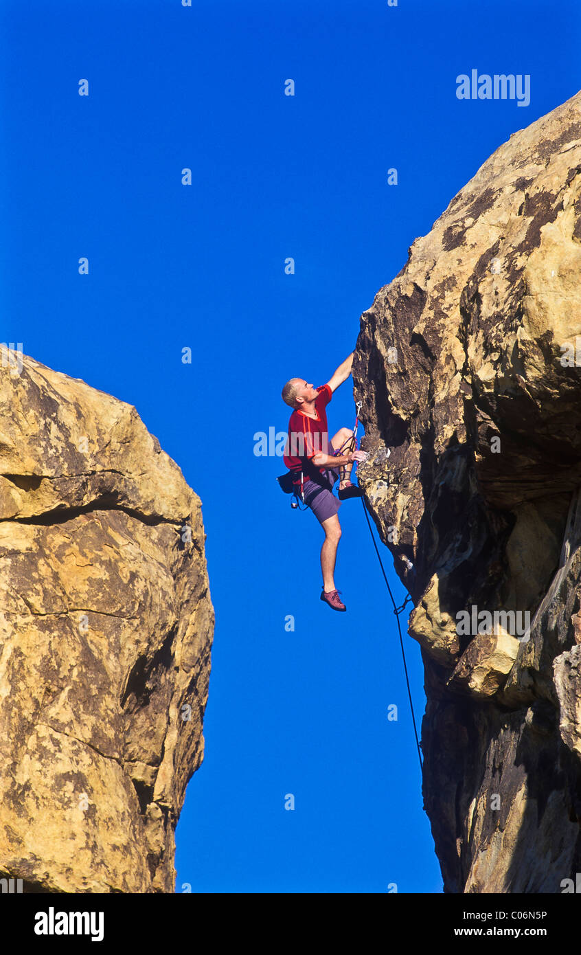 Rock climber struggles for his next grip on a overhanging cliff Stock ...