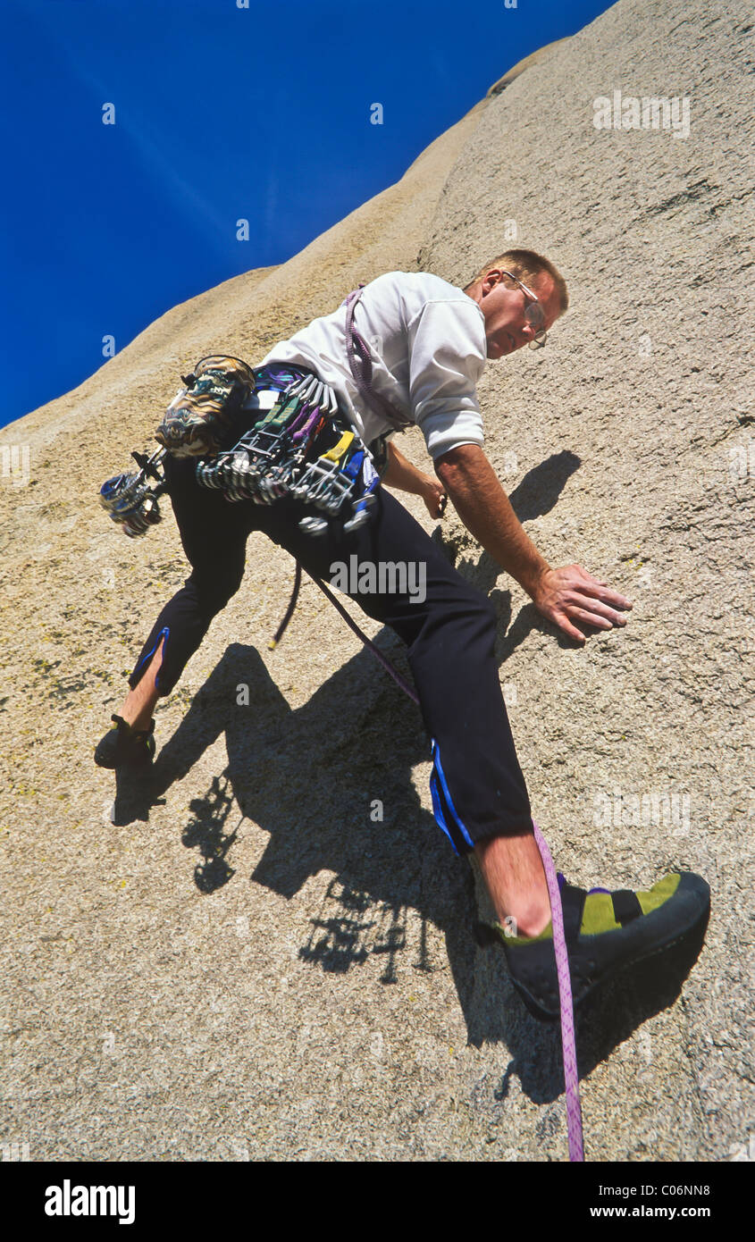 Rock climber struggles for his next grip on a overhanging cliff Stock ...