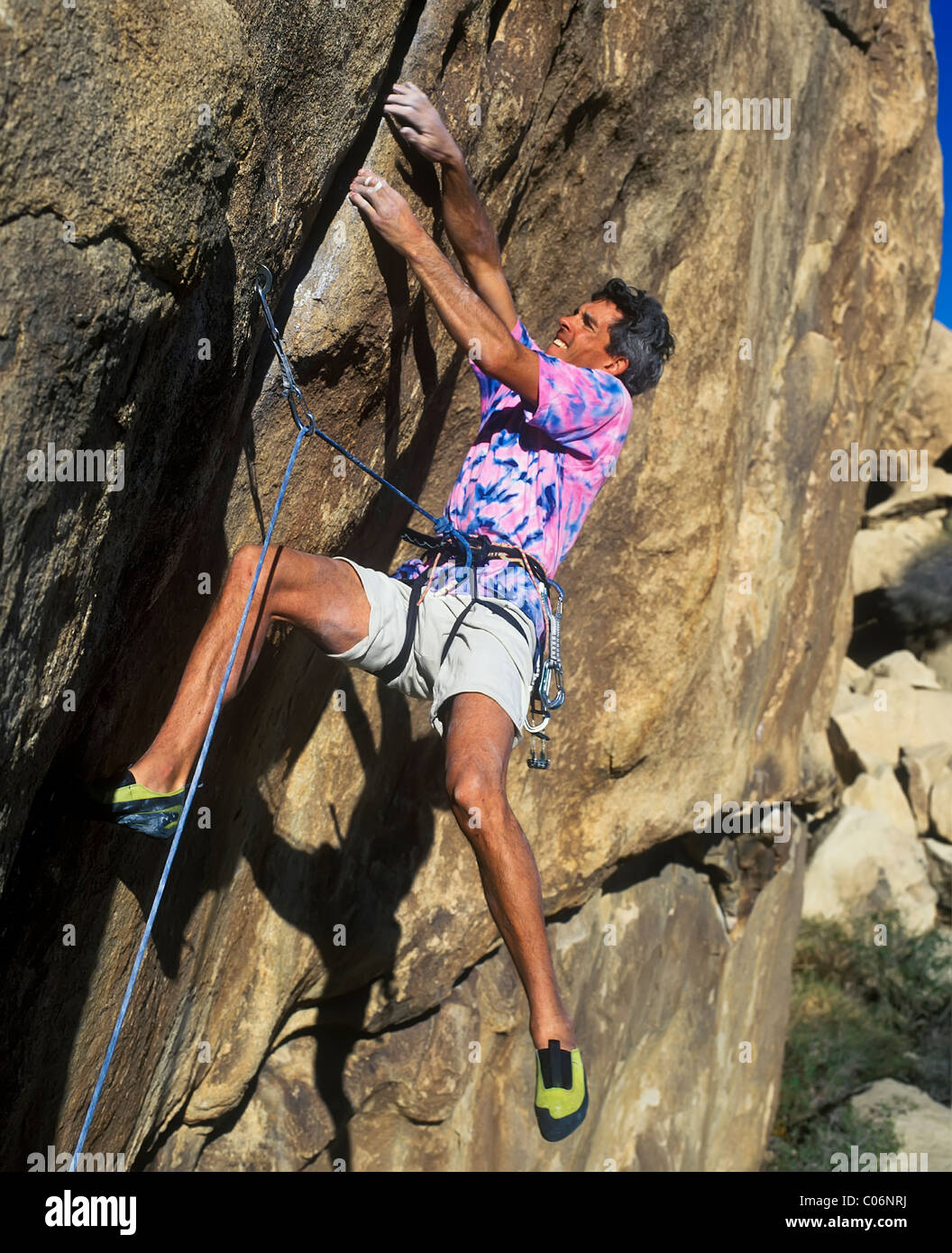 Male rock climber clinging to a cliff Stock Photo - Alamy