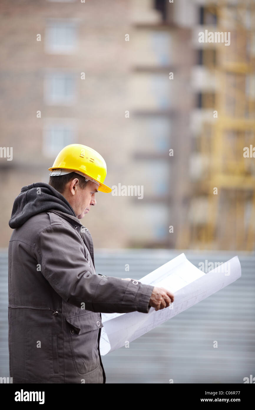 real builder with blueprints on construction site Stock Photo - Alamy
