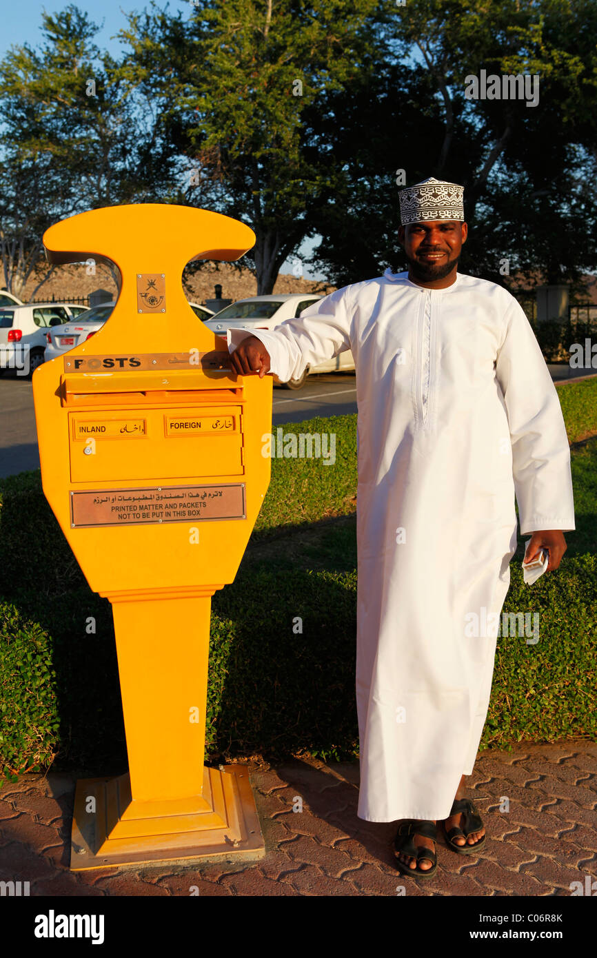 An Omani man wears the traditional Omani national dress of a long white ...