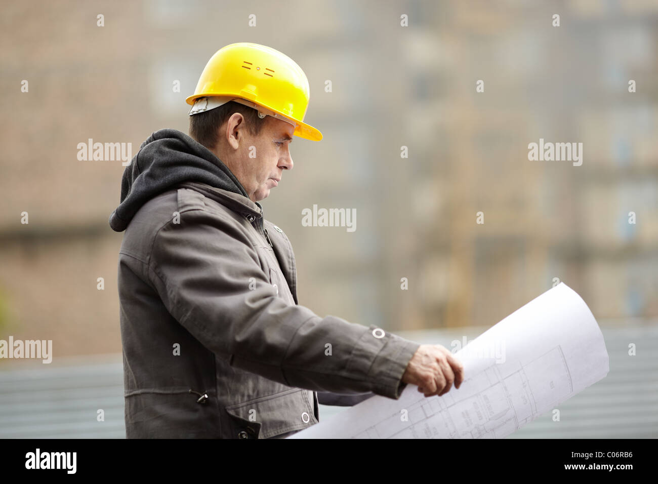 real builder with blueprints on construction site Stock Photo - Alamy