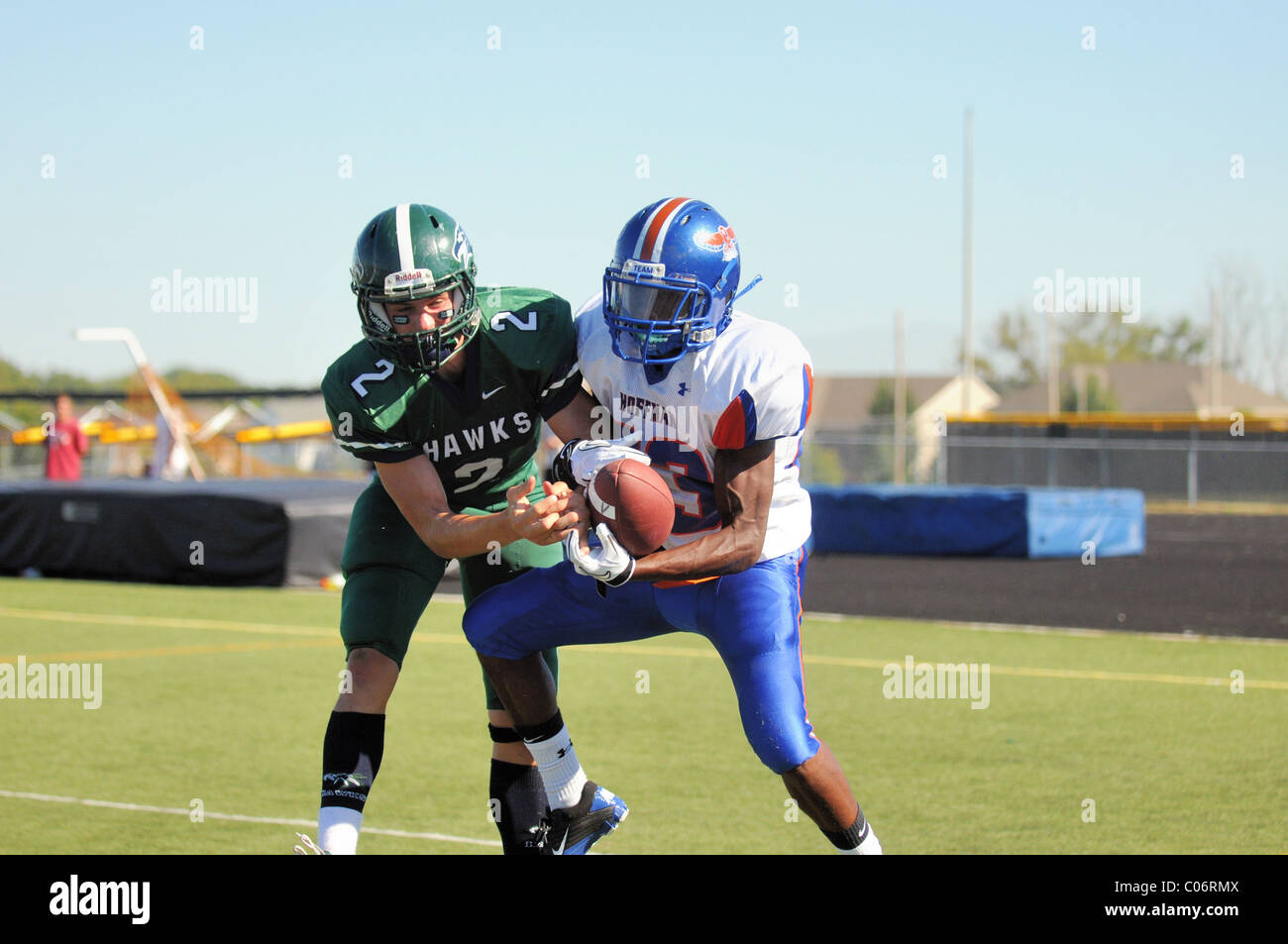 Pass receiver and defensive back battle for possession of a pass during ...