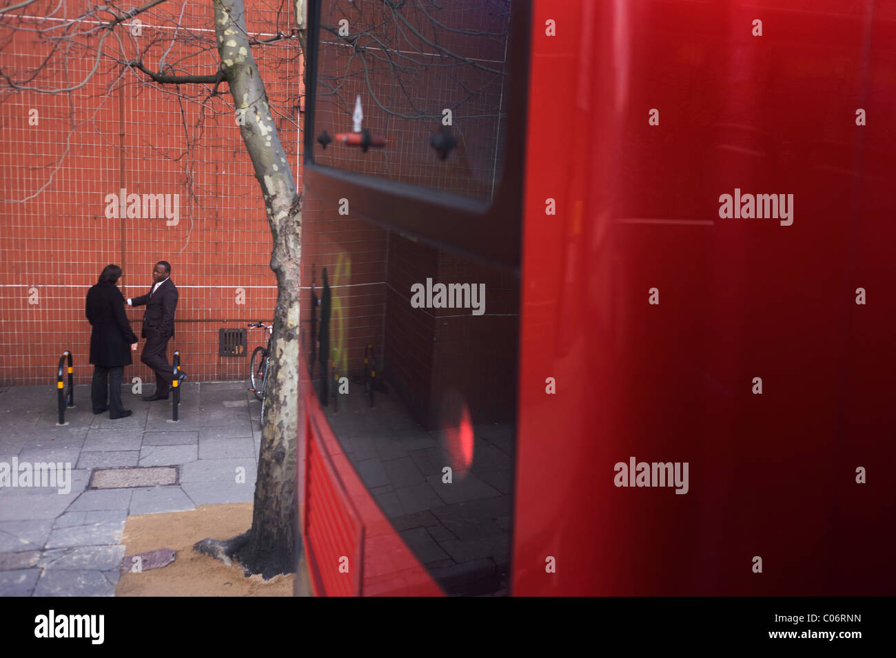 Two male smokers stand chatting outside their University building, seen ...