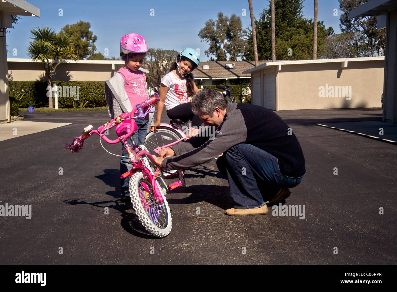 Dad Helps His Five Year Old Daughter Learn To Ride Her New Bicycle With