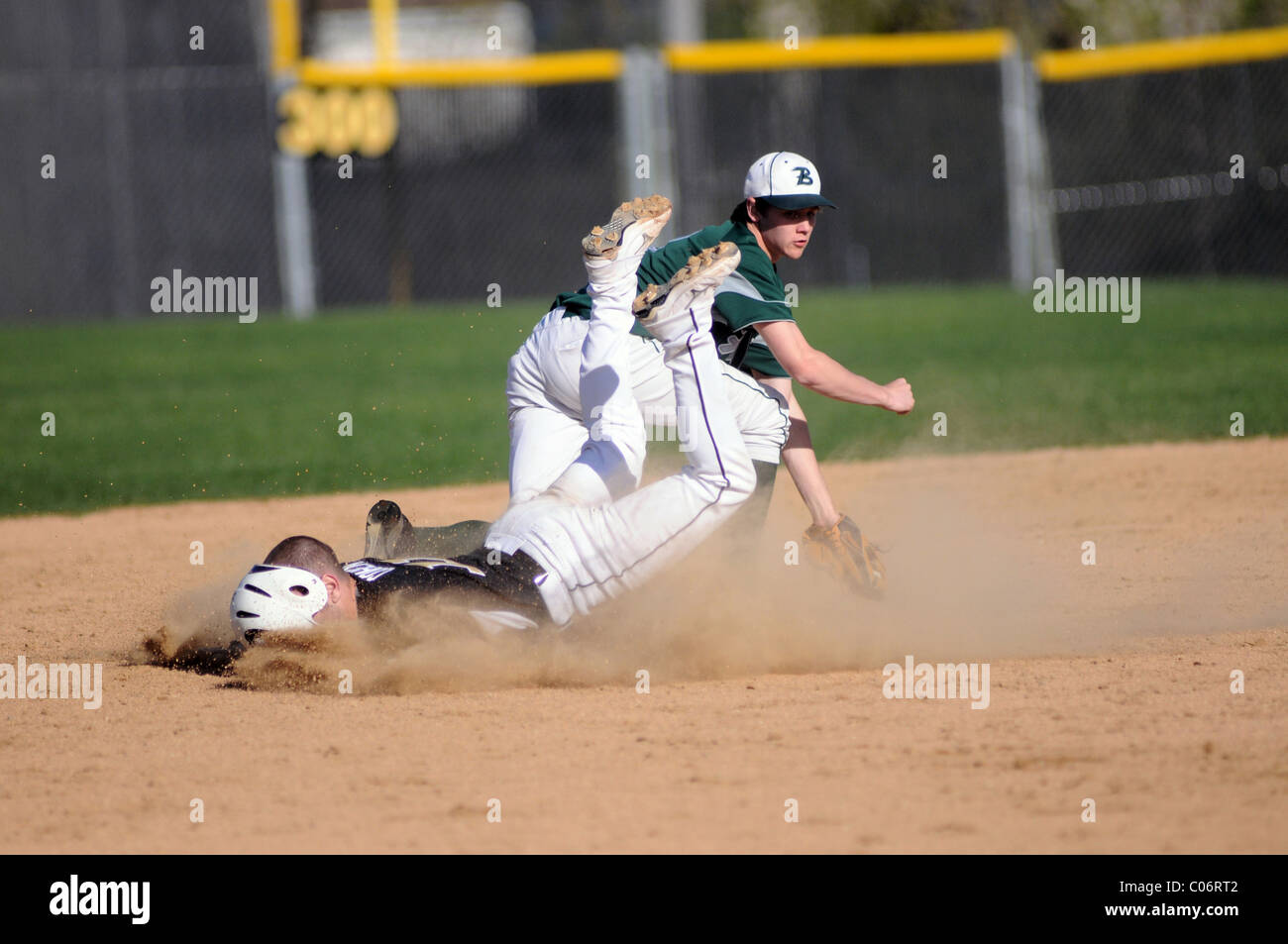 Base runner arrives abruptly at second base and gains a face full of ...