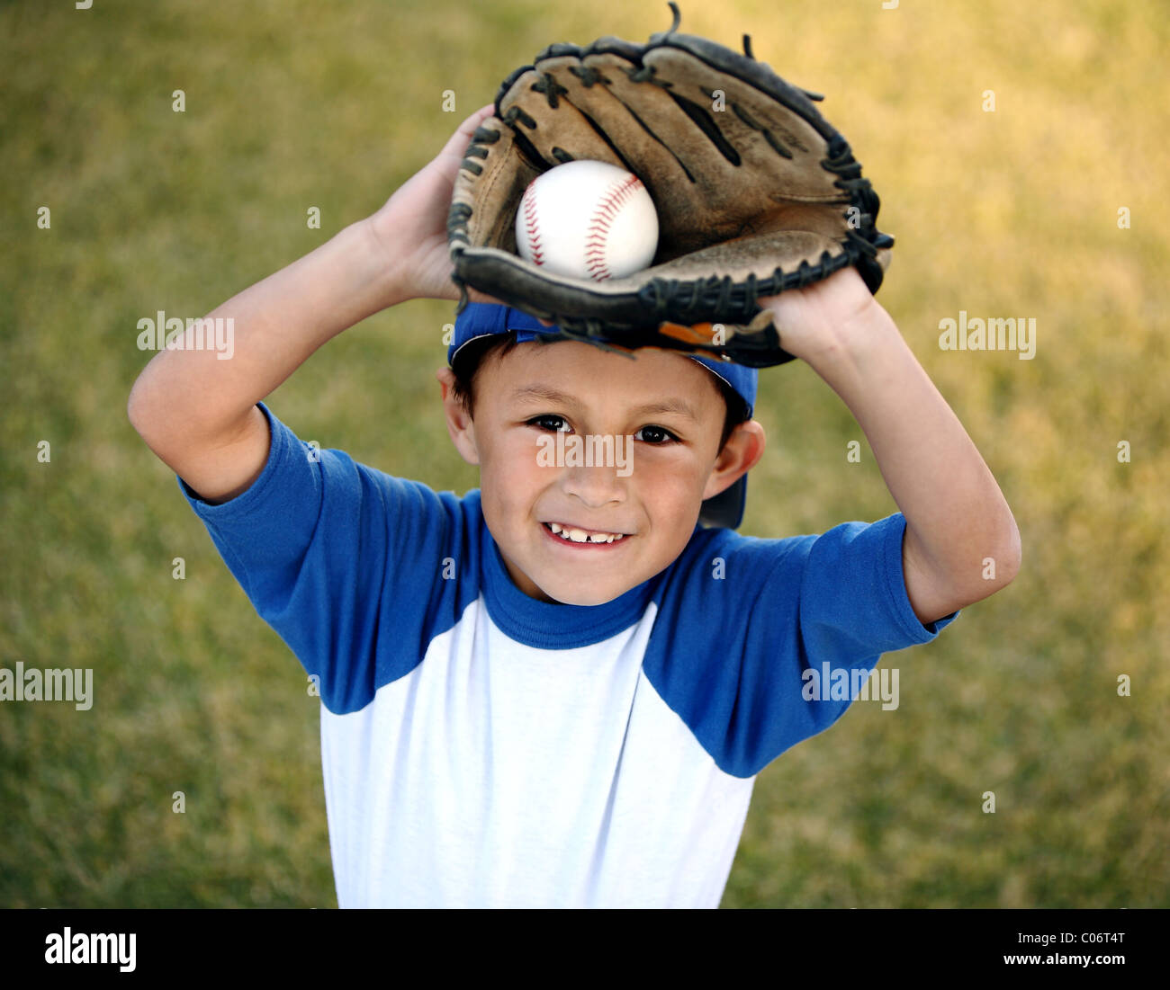 Happy smiling young Latino boy dressed in blue baseball sleeves with ...