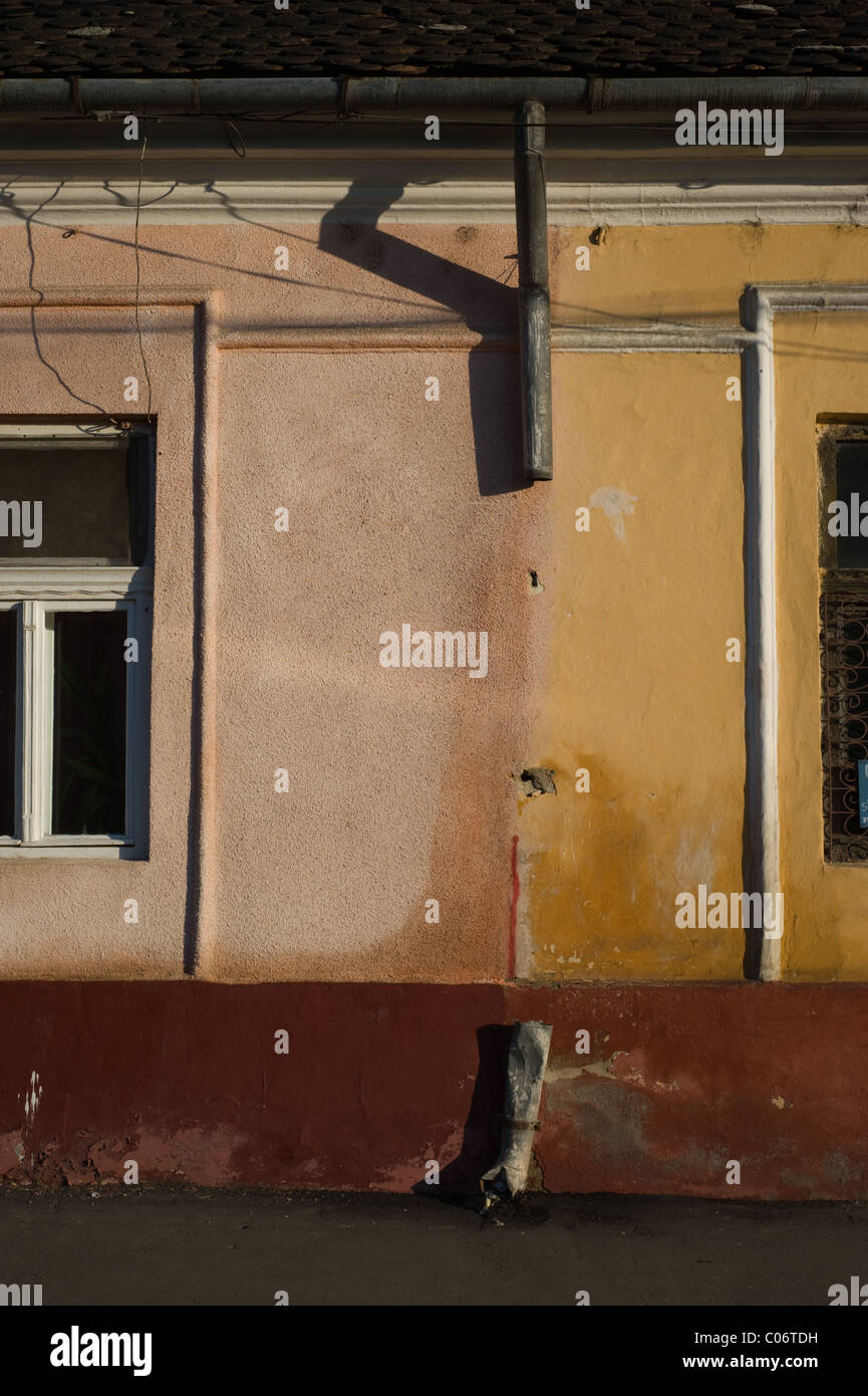 Architectural detail in Gherla, Romania. Broken pipe and sunlit painted ...