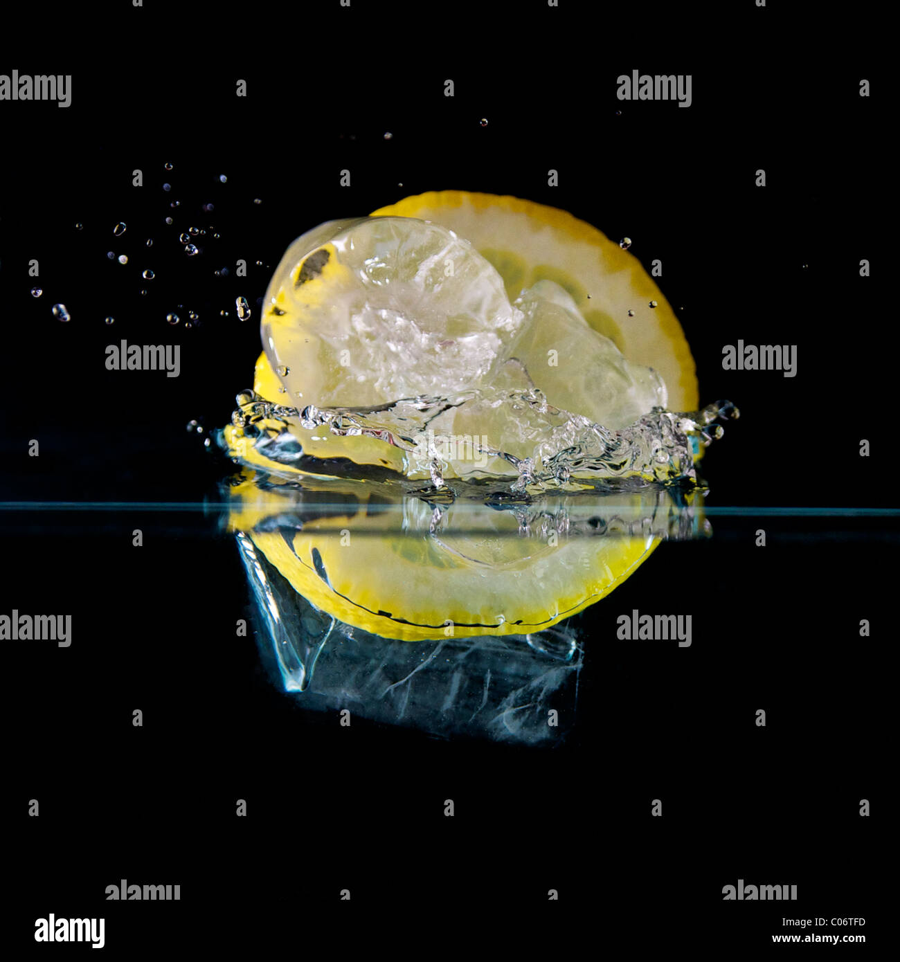 Slice of lemon and ice dropped into water Stock Photo - Alamy