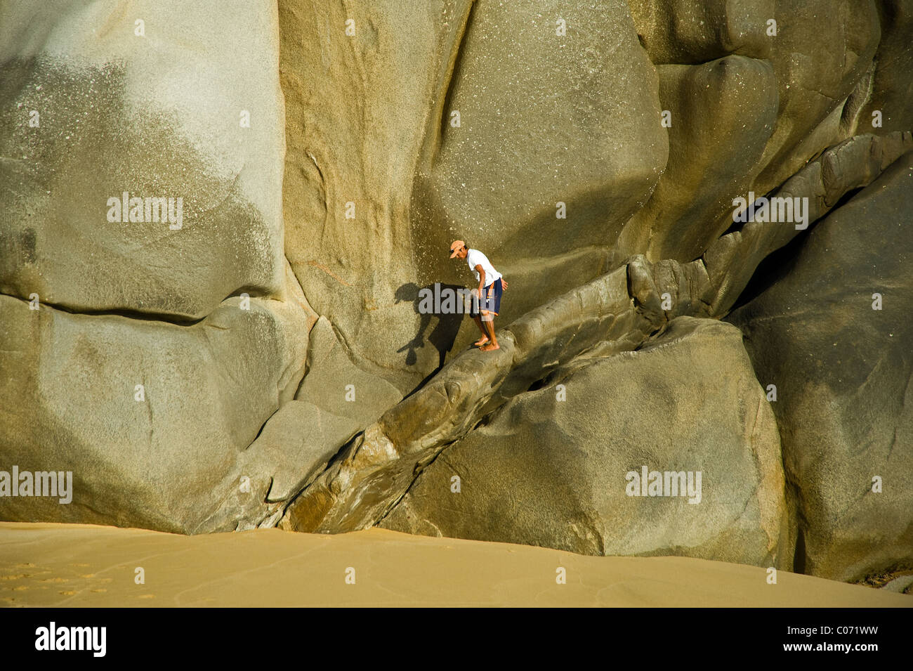 young Mexican man running down rock formation near San Lucas Mexico ...