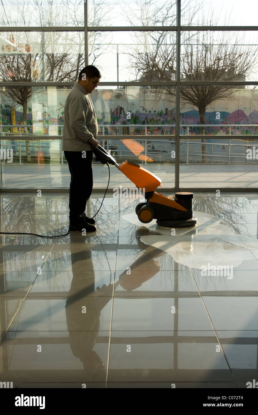 A cleaner is cleaning the floor with machine Stock Photo - Alamy