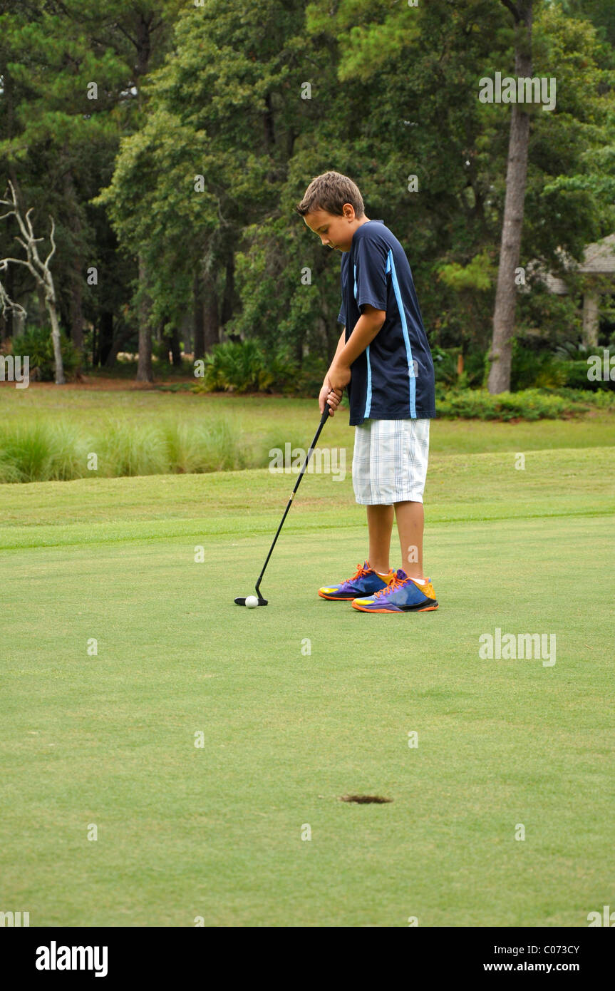 Young boy putting on a golf course Stock Photo - Alamy