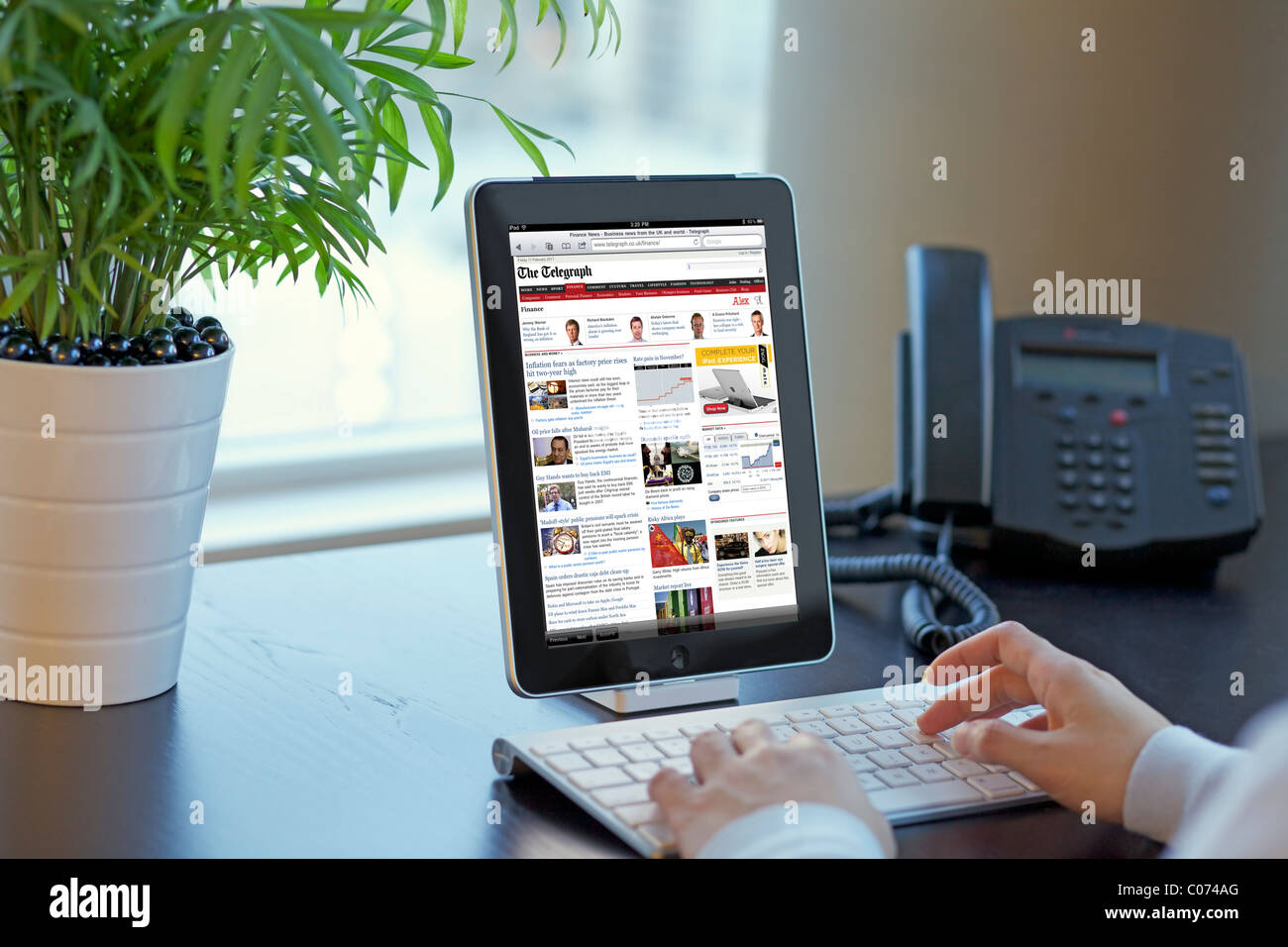 Young woman searching news "The Telegraph" website from an iPad ...