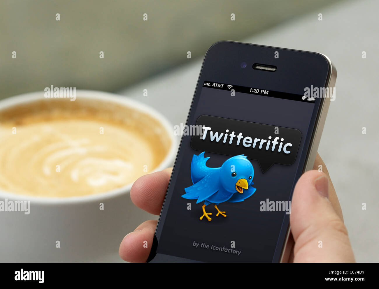 Man hand holding an iPhone 4 showing the Twitter application screen at ...