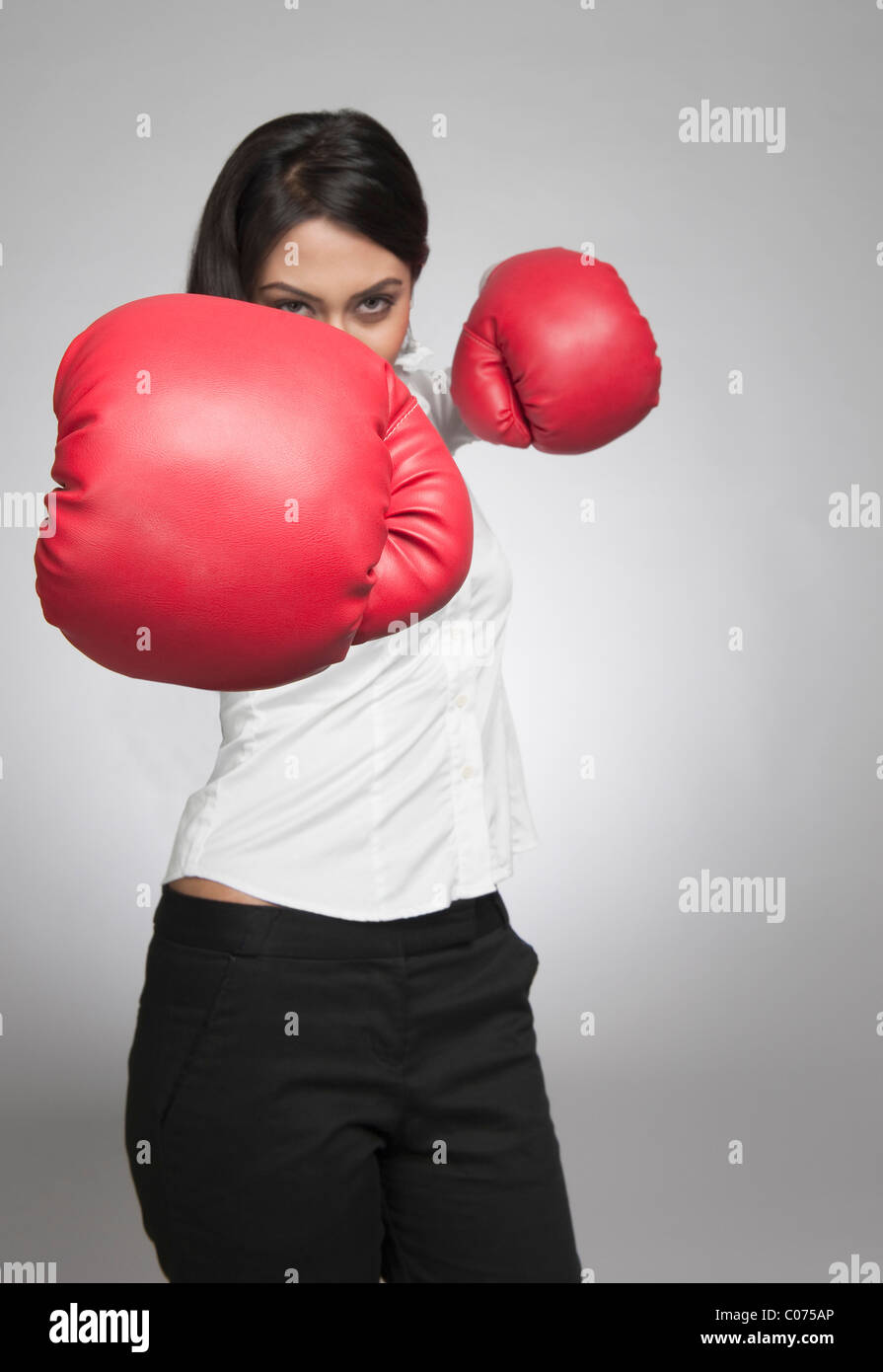 Businesswoman punching with boxing gloves Stock Photo - Alamy